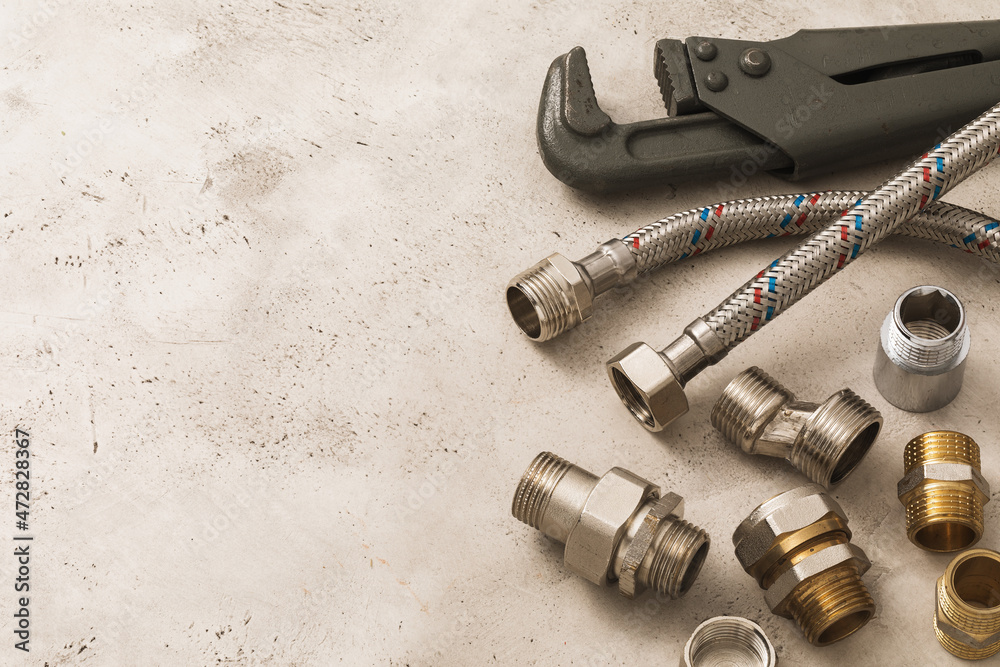 Adjustable wrench, flexible water hoses and connecting adapters on the ...