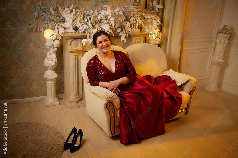 A beautiful majestic solemn fat queen in a red elegant dress in a ...