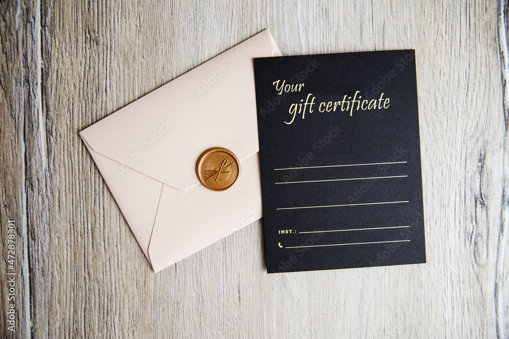 Decorative beige envelope, gift certificate and black letterhead with ...