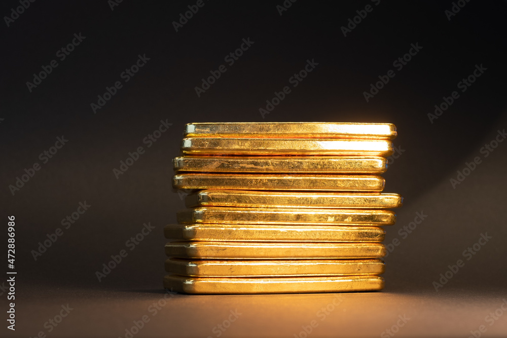 Gold bullion bars on black background. Stack of large cast investment ...