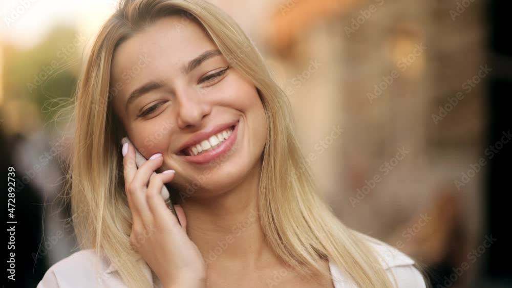 Happy blessed woman with blonde hair talking on mobile phone and ...