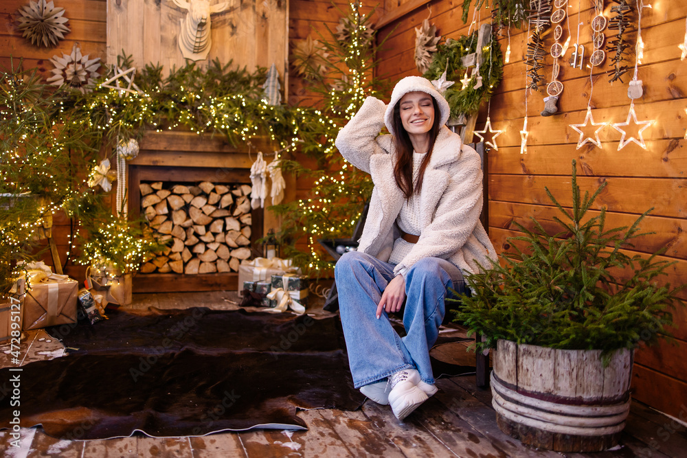 Beautiful young stylish woman on the veranda in winter. Terrace of a ...