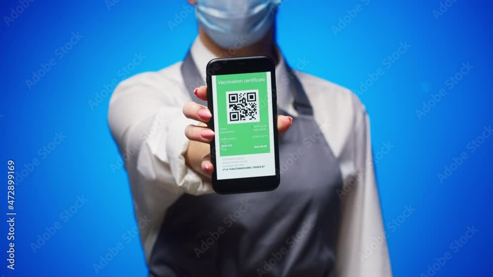 Woman worker showing on phone vaccination passport with qr code on blue ...