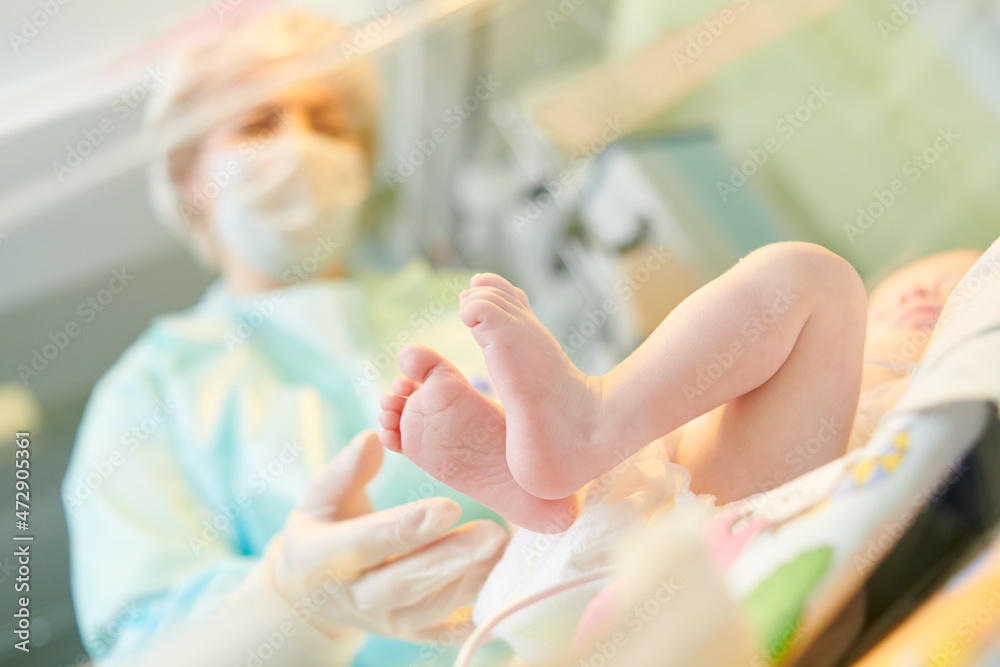 doctor examining newborn baby in incubator at neonatal resuscitation ...