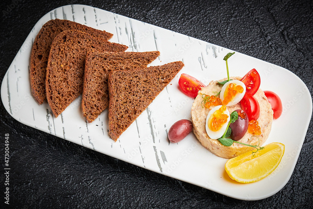 Jewish traditional dish Forshmak on white plate on black background ...