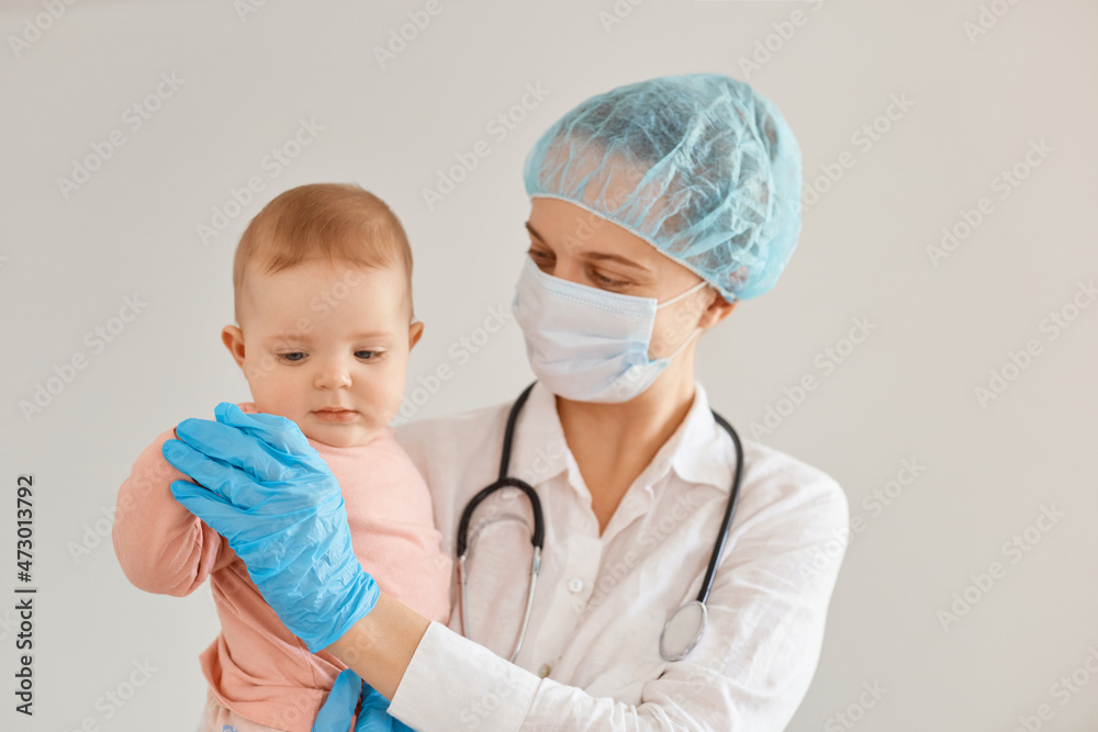 Good looking kind young adult female pediatrist wearing medical uniform ...