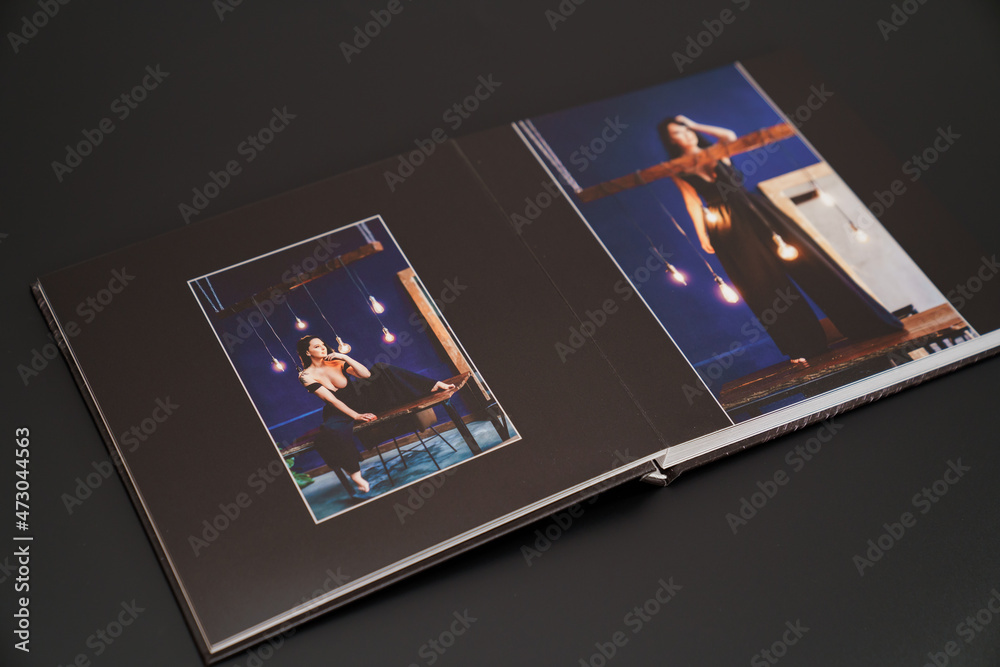 open photobook from a photo shoot of an attractive woman on a black ...