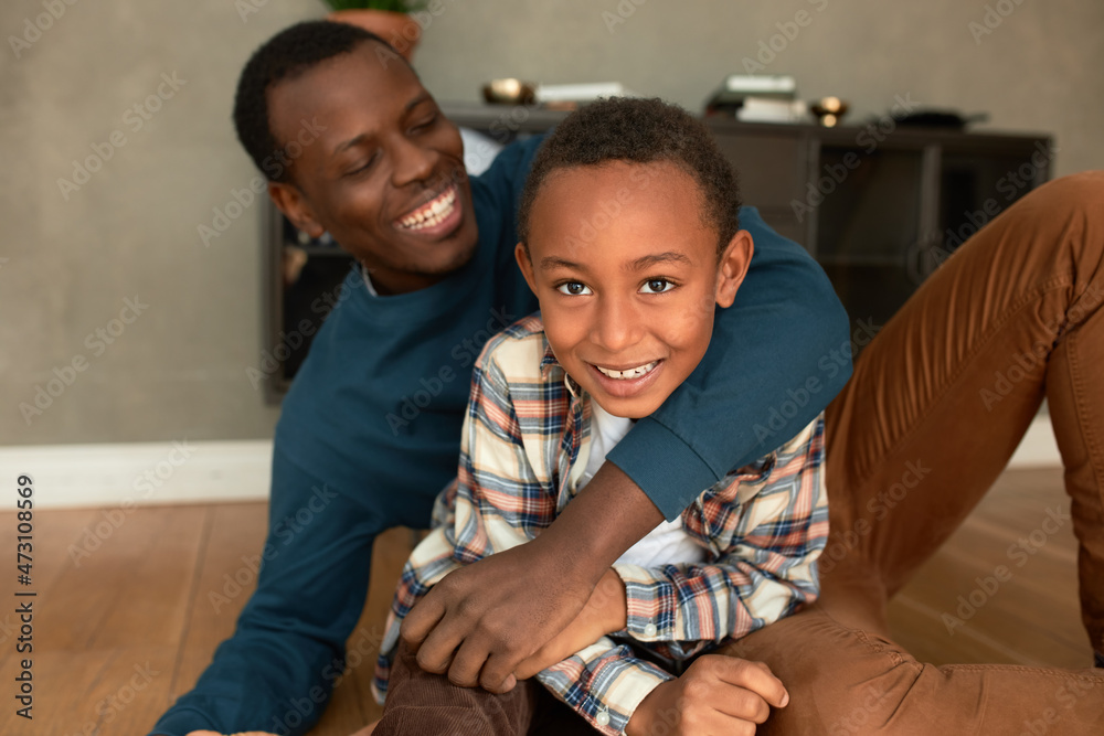 Human relationships. Positive emotions. Dark-skinned dad showing his ...