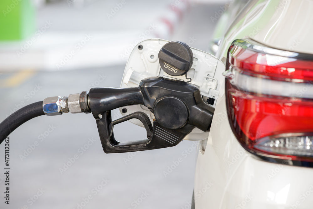 refilling the white car with diesel fuel at the refuel station. diesel ...