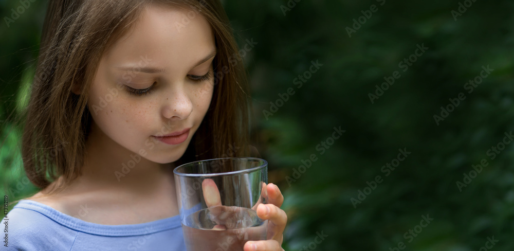 Cute girl drinking water. Little young lady holds glass of clean ...