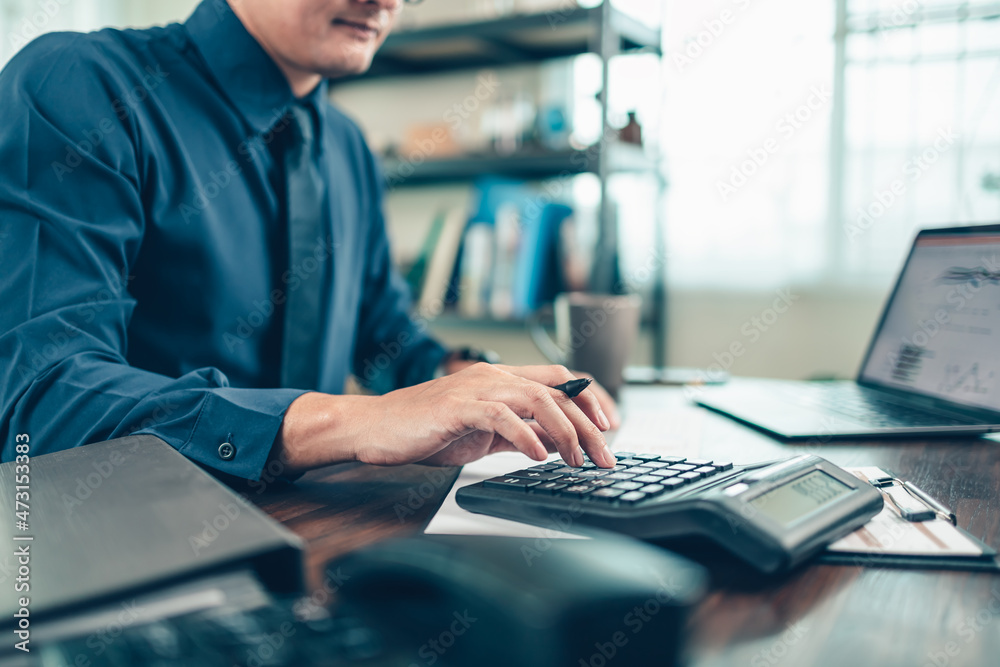 Financial businessman working on desk office using a calculator to ...