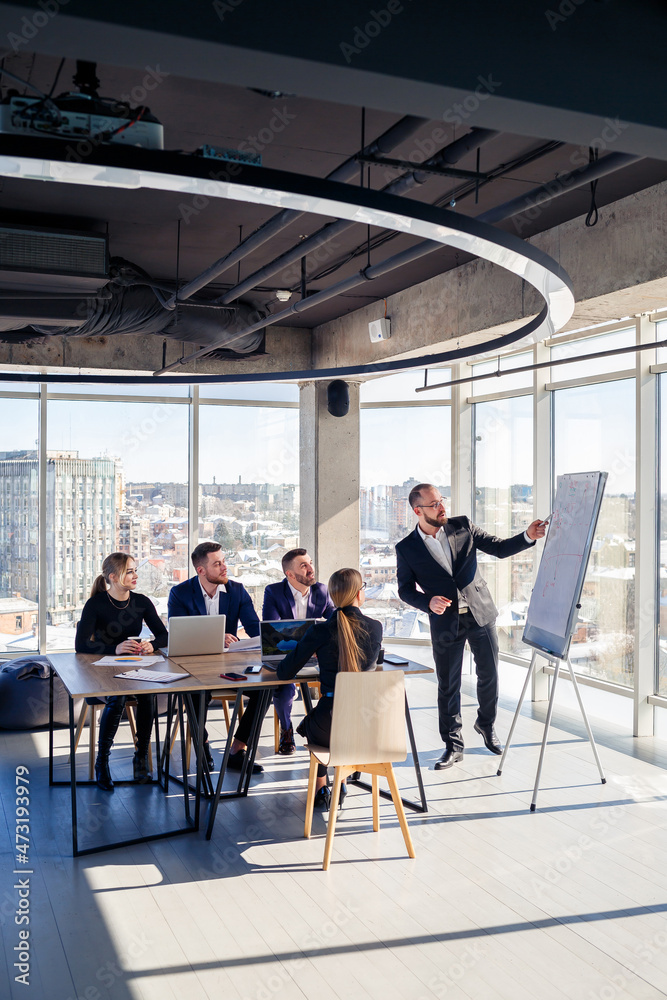 The boss stands near the board with graphs, demonstrates statistics ...