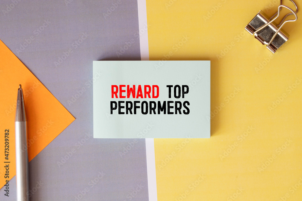Reward top performers text memo written on a white background with ...