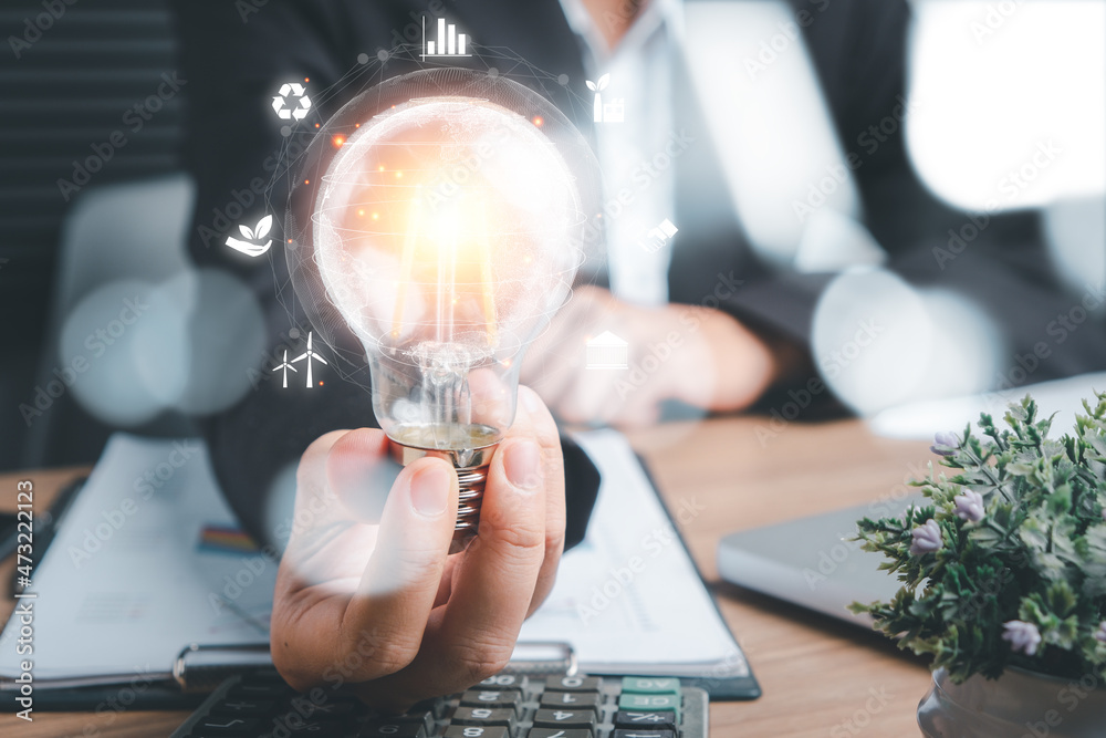 Businesswoman hand holding light bulb with esg icon on virtual screen ...