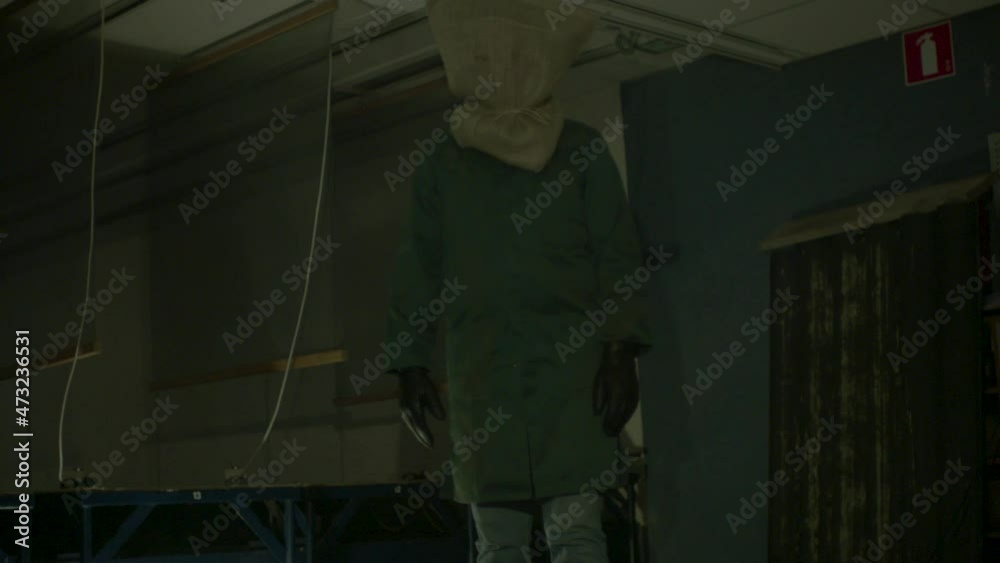 Stockvideon Serial killer wearing a burlap sack walking towards camera ...