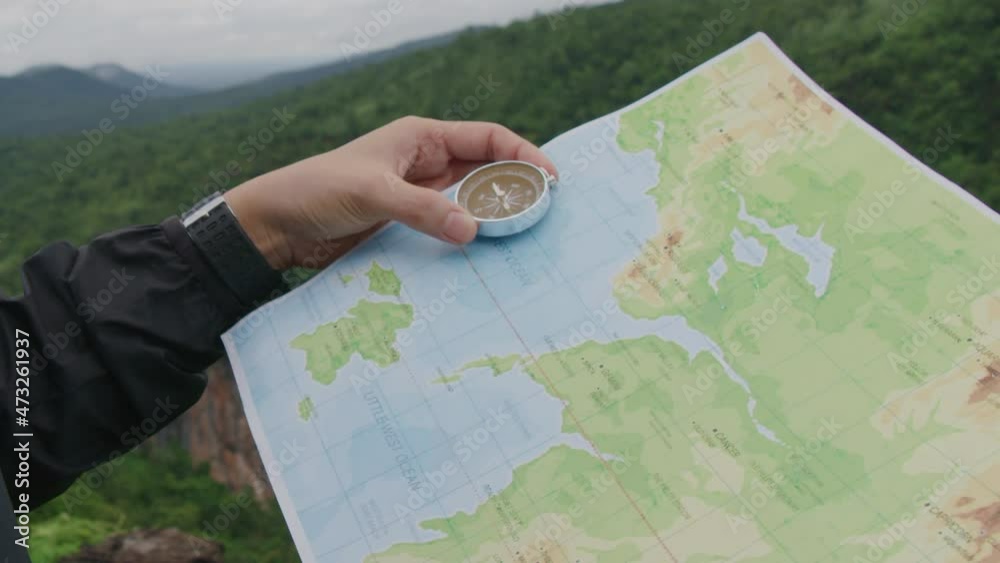 Compass and map in hands of traveler for checking and searching ...