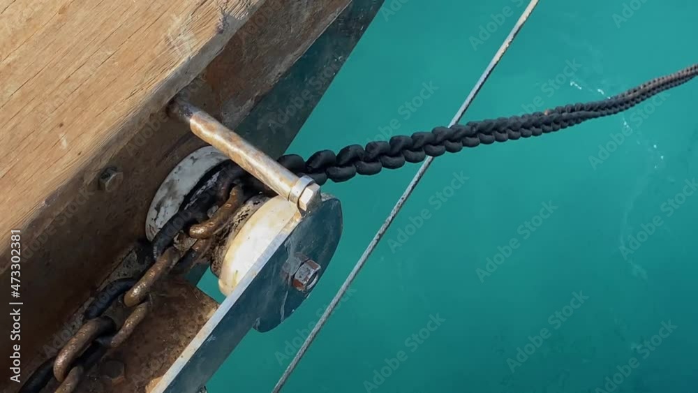 sliding of the anchor chain along the tension roller on the bow of the ...