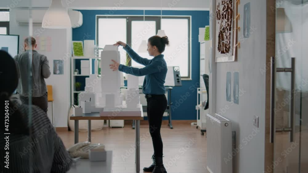 Woman engineer looking at building model to design construction layout ...