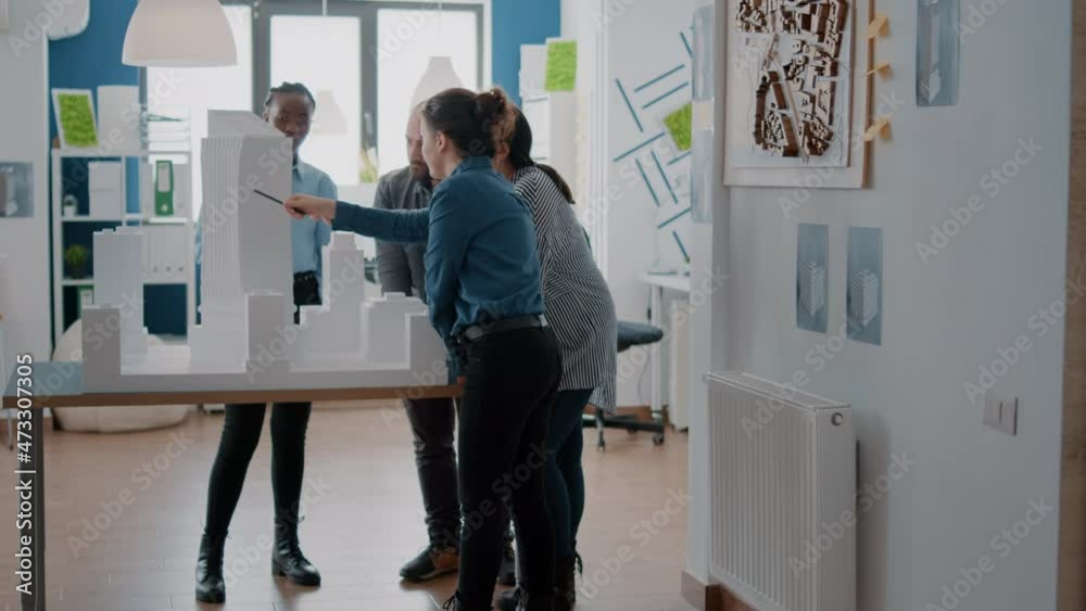 Multi ethnic people working with building model to design urban ...