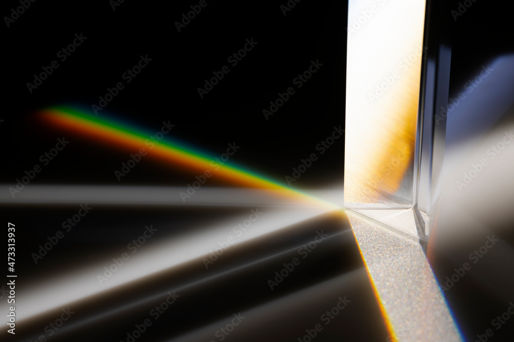 Triangular Prism dispersing sun beam splitting into a spectrum on white ...