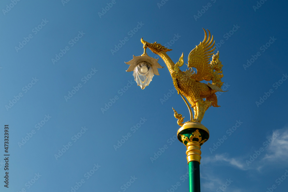 A Lamp hangs on A golden mythical Hongsa, swan, figure topped on a pole ...