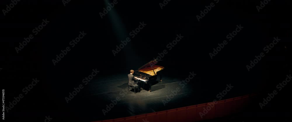 WIDE HIGH ANGLE Young 20s aspiring musician playing grand piano on a ...
