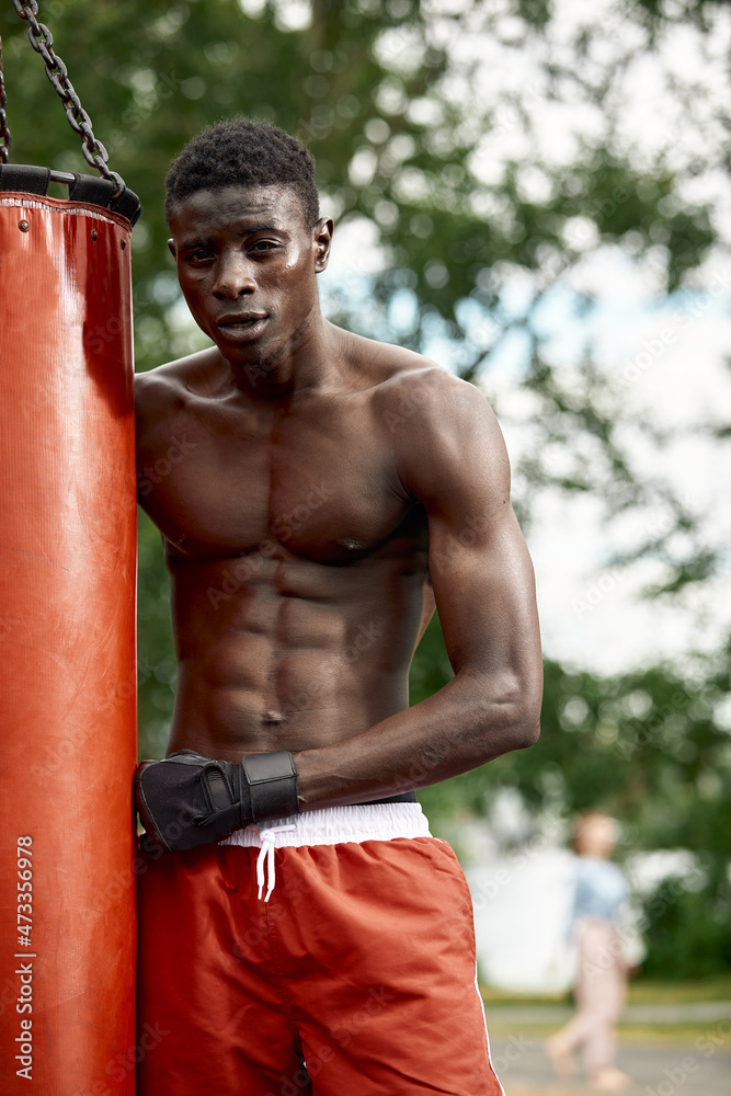 Front view of muscular black boxer punching towards camera with a deep ...