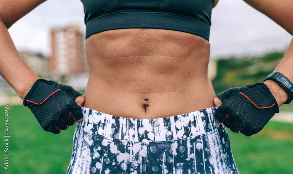 Female athlete posing showing abdominal muscles Stock Photo | Adobe Stock
