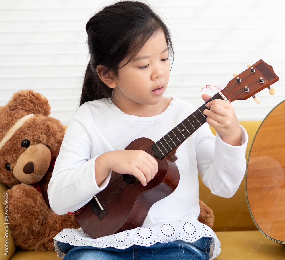 Adorable little kid musician holds ukulele chords strumming songs. Cute ...