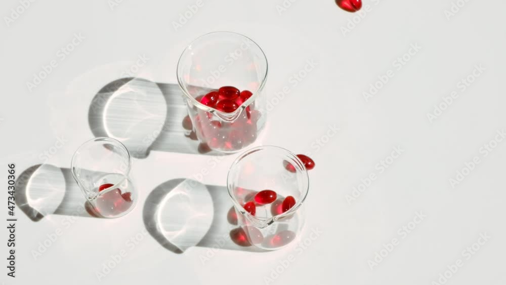 Krill oil gelatin capsules in laboratory transparent flasks on a white ...