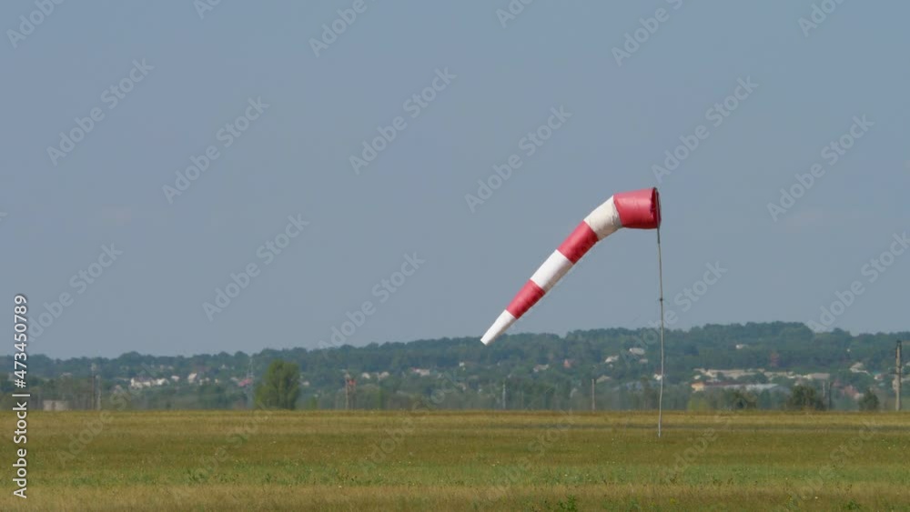 Striped cone airsock indicator of wind direction and speed. Red white ...