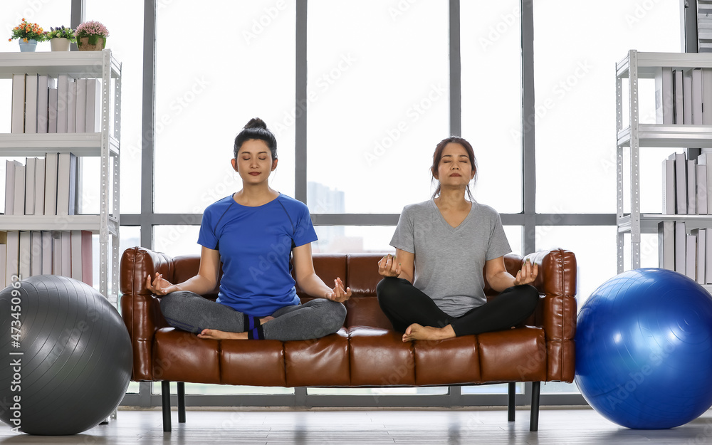 Charming and healthy Asian woman sitting cross legged camly, eye close ...