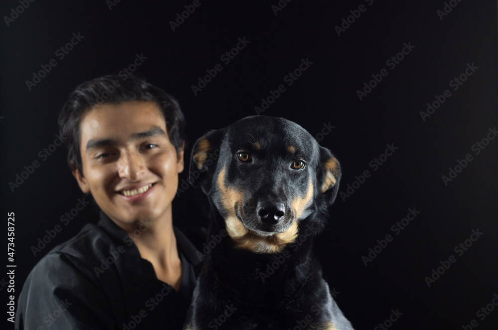 boy carrying his dog, both posing for the picture, the dog has a tender ...