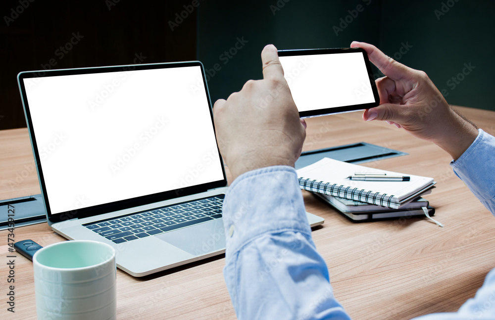 Businessman using smart phone to take picture of laptop screen and ...
