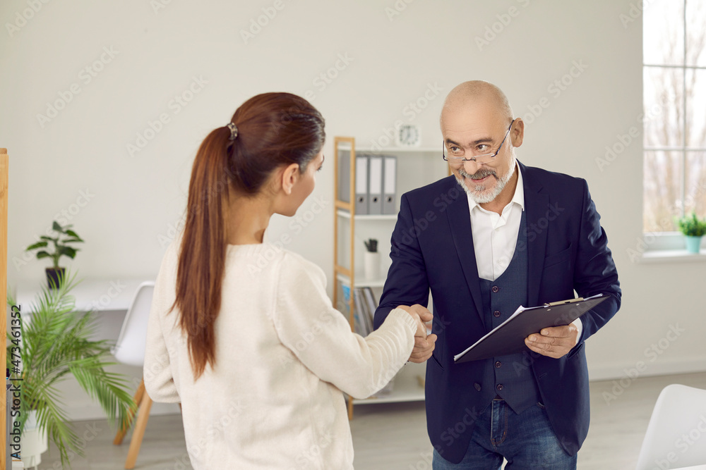 Real estate agent or loan broker making business deal and shaking hands ...