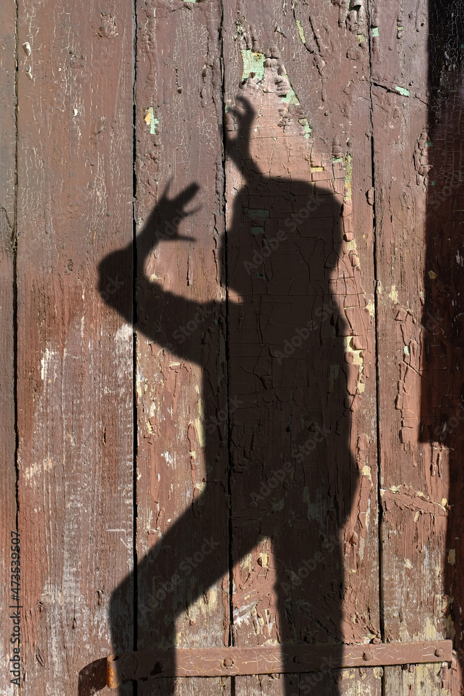 shadow of a child with raised hands in a pleading gesture against the ...