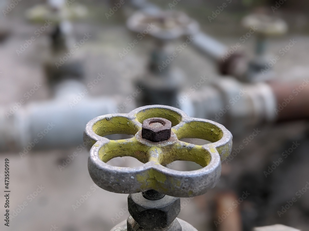 A steel made tap knob with a screw on top and bottom is placed on a ...