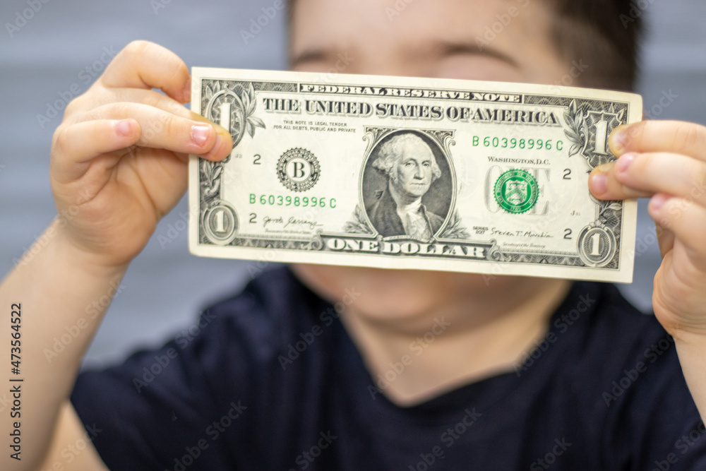 one dollar bill in front of kid child boy face cover eyes or mouth ...
