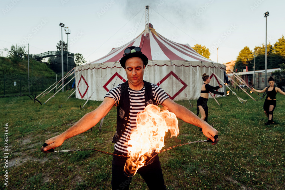 Male fire dancer holding fire equipment while practicing in front of ...