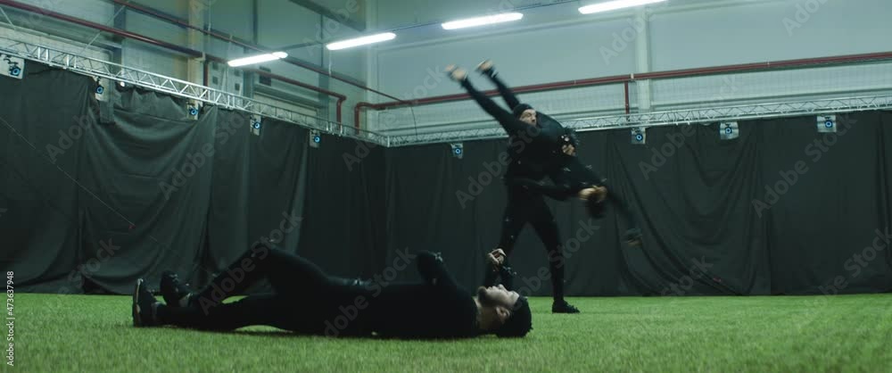 Actors wearing motion capture suits performing some fight moves as game ...