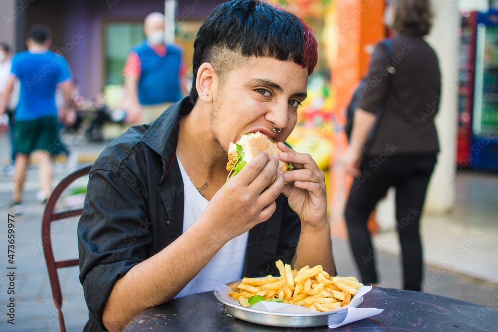 Cool gen z latino guy eating comfort food Stock Photo | Adobe Stock