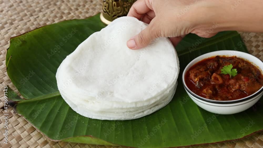 Rice Pathiri pathir flat bread spicy chicken curry woman hand serving ...