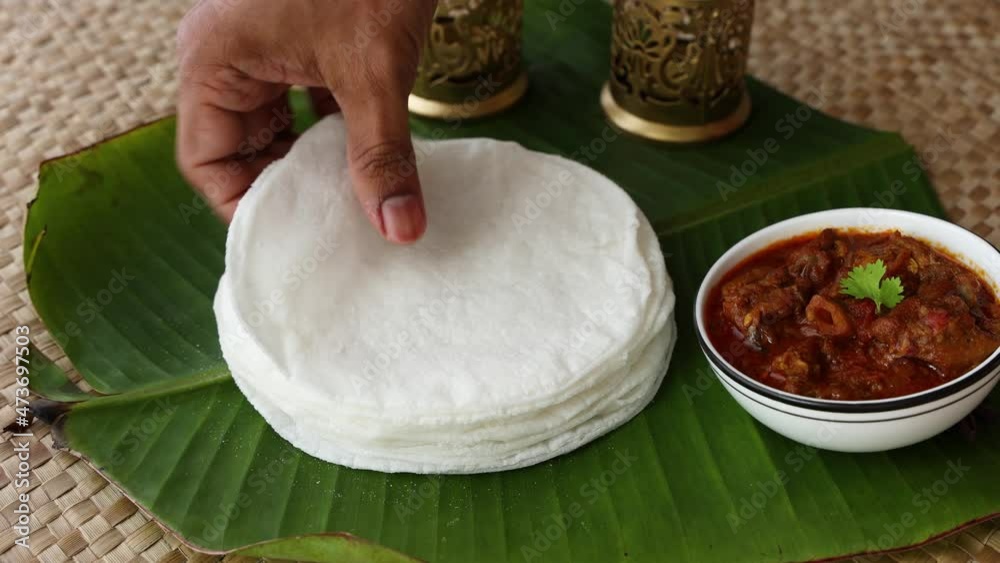 Rice Pathiri pathir flat bread spicy chicken curry woman hand serving ...