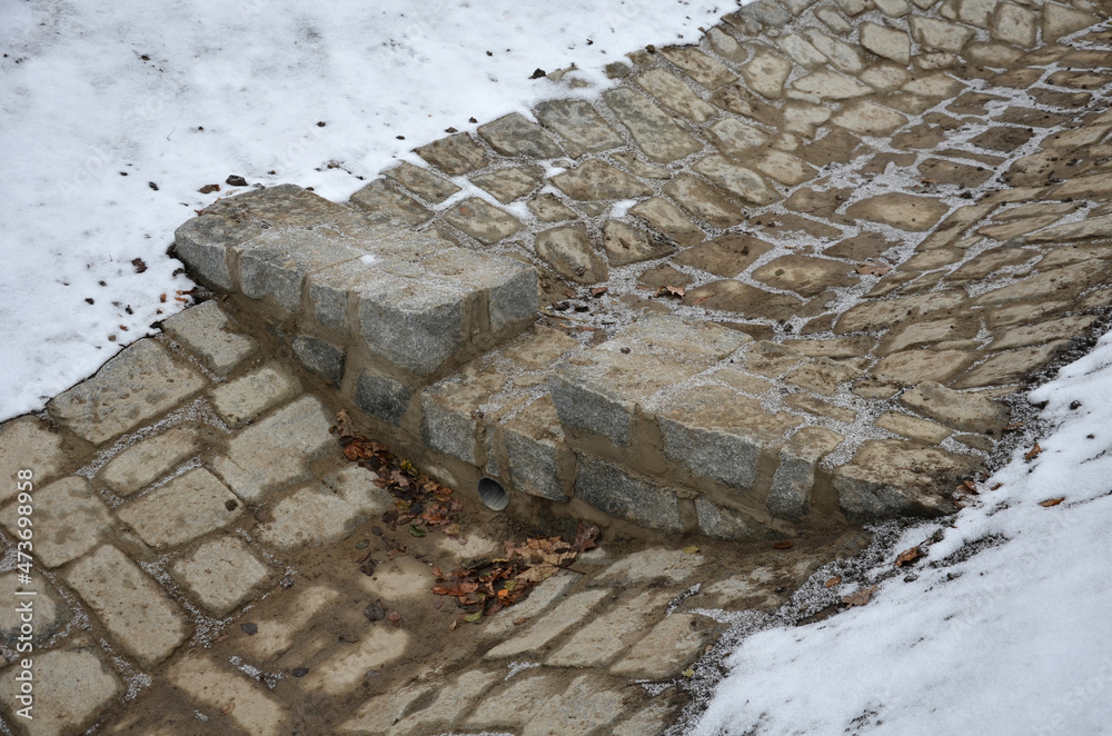 Sewer gutter paved with granite stone and dikes drains rainwater by ...