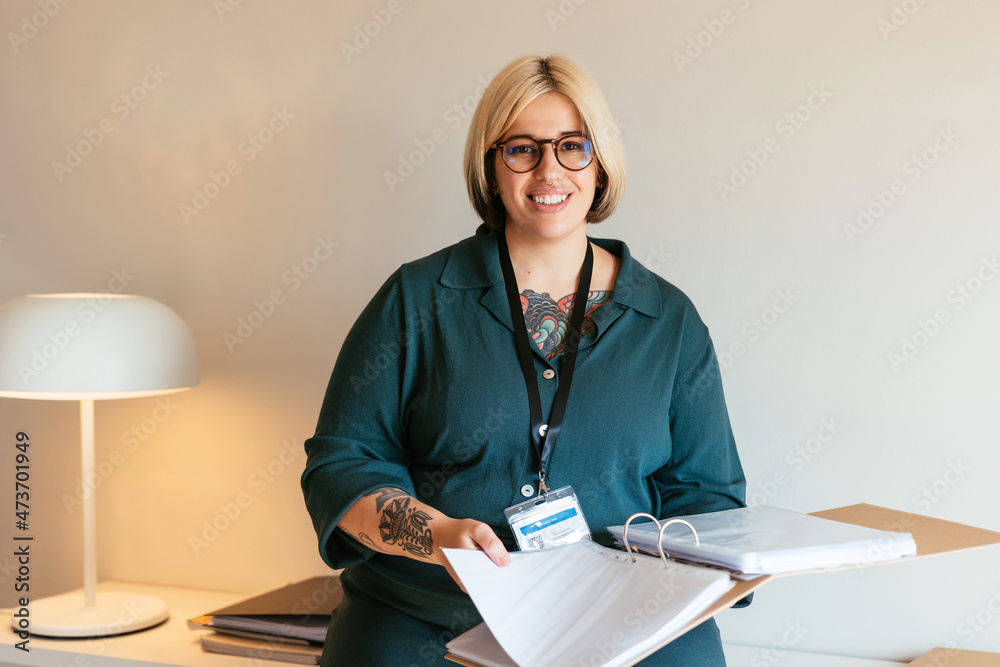 Cheerful female employee with folder Stock Photo | Adobe Stock