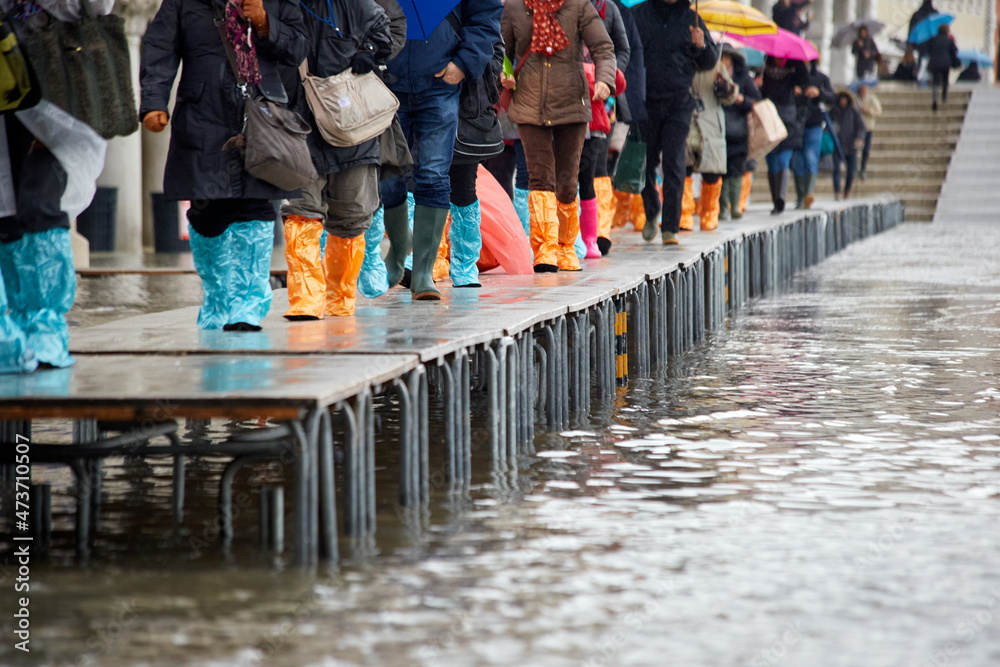 Water floods Venice footpaths, feet on raised walkway Stock Photo ...