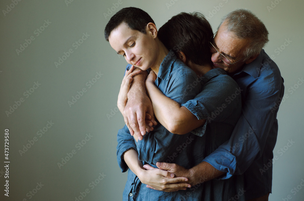 Parents hug their young daughter Stock Photo | Adobe Stock