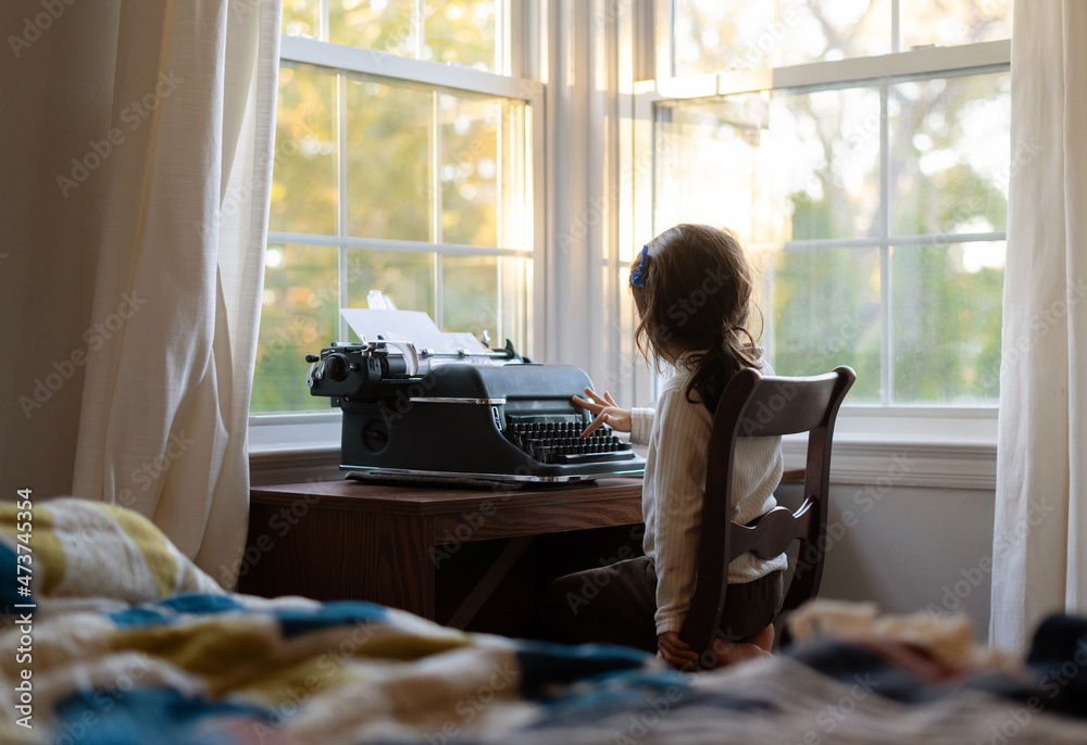Little girl typing and being creative on typewriter Stock Photo | Adobe ...