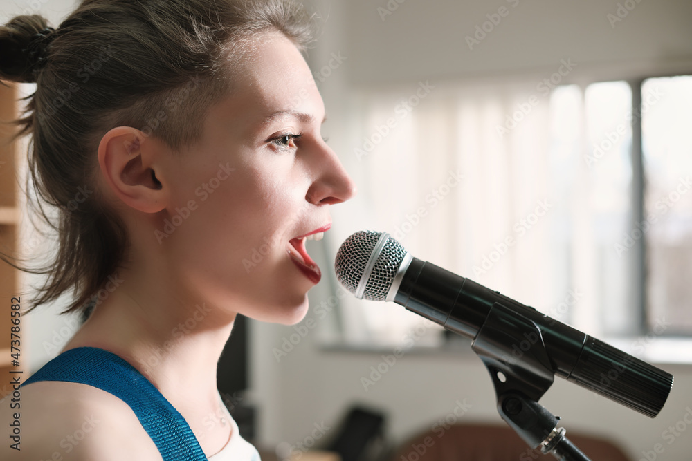 young emotional woman singing into a microphone. female rock singer on ...