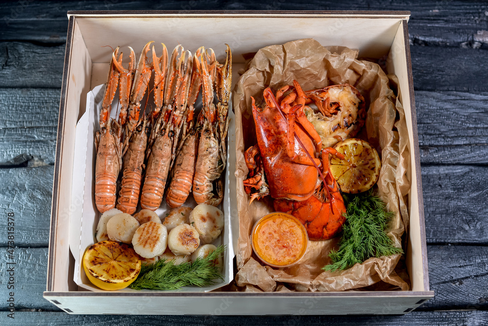 big box with giant crayfish and scallop scampi on black background ...
